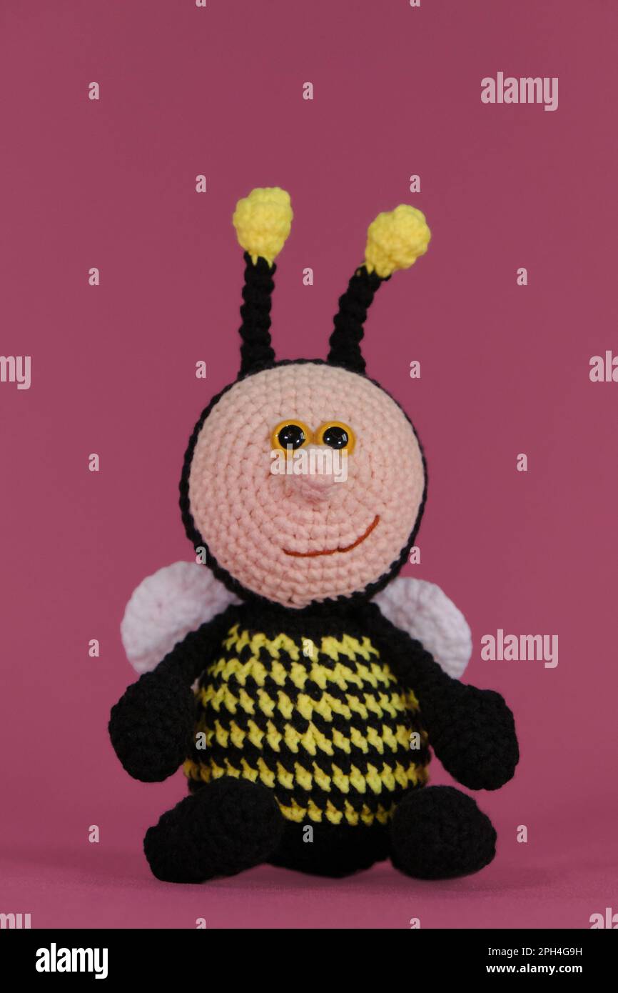 Amigurumi bumblebee doll on pink background. Soft DIY toy made of ...