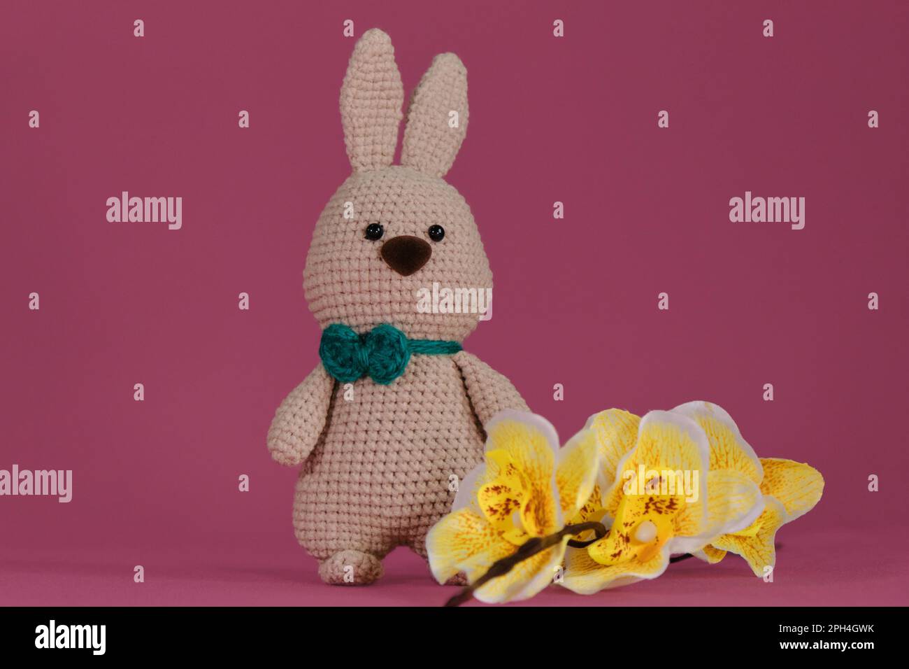 Symbol of Catholic Easter. Amigurumi rabbit doll on pink background ...