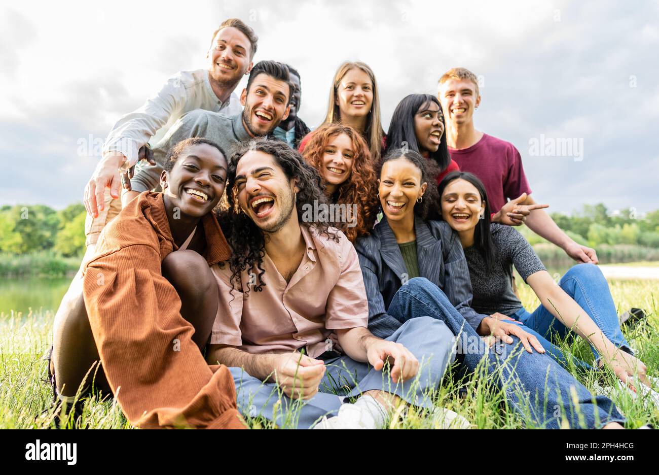 Multiracial group of students laughing together outside at park - Integration, diversity, and ...