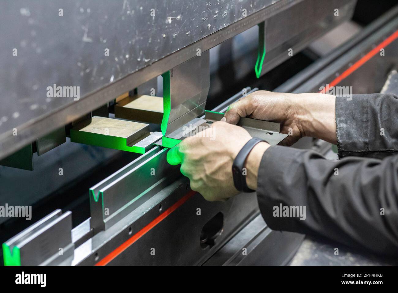 Worker holds a part in a CNC bending machine Stock Photo - Alamy
