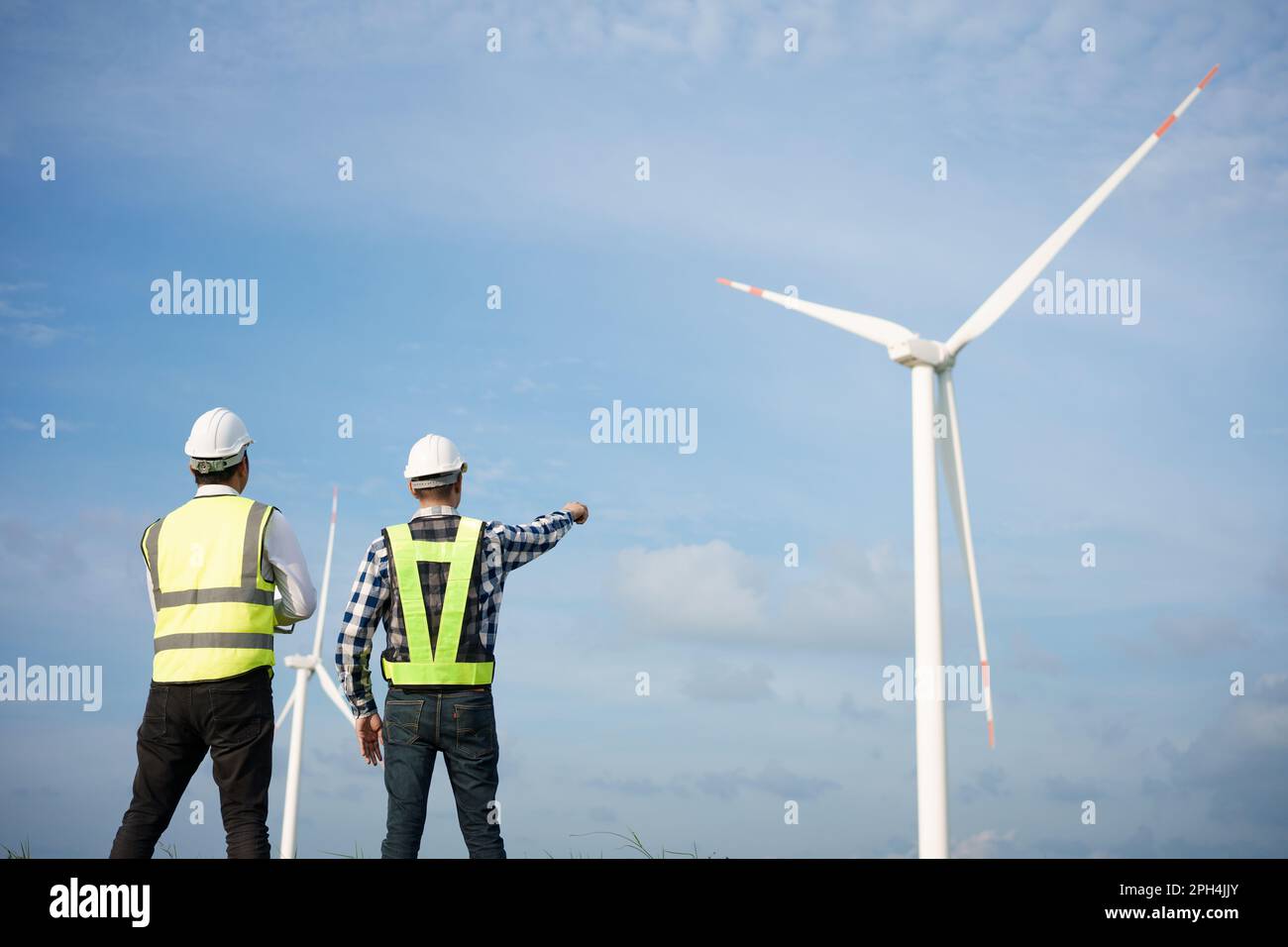 Two asian engineers discussing and checking turbines on wind turbine ...