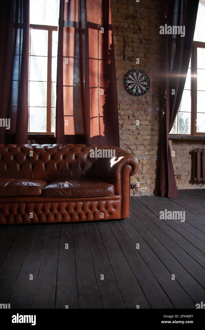 Windows at empty Library room with a brick wall. Leather sofa in a ...