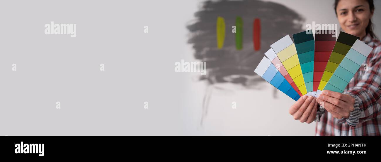 Beautiful young woman holding color palettes on light background with ...