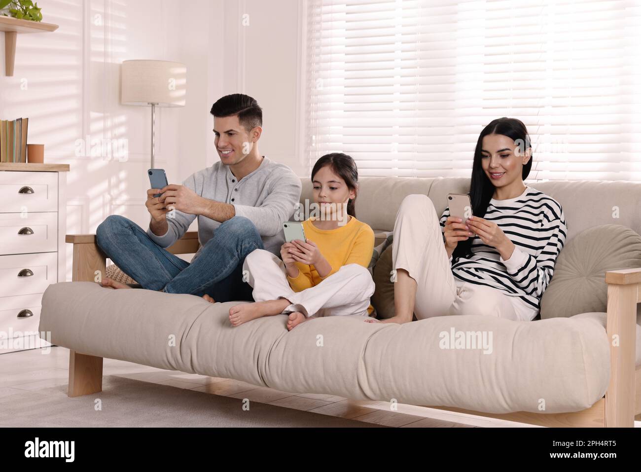 Internet addiction. Family with gadgets on sofa in living room Stock ...