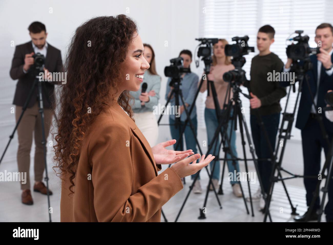 Happy African American business woman talking to group of journalists ...