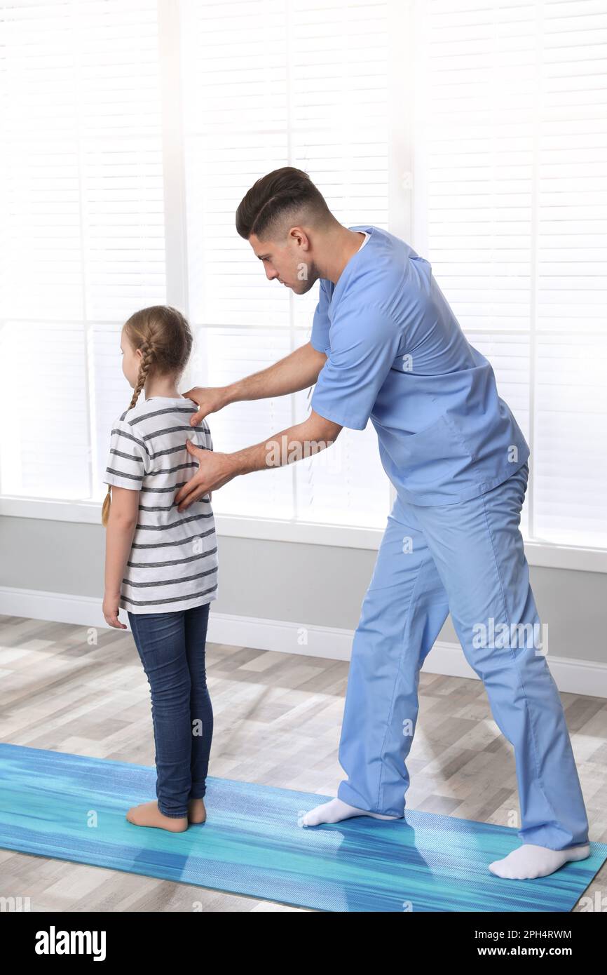 Orthopedist examining child's back in clinic. Scoliosis treatment Stock ...