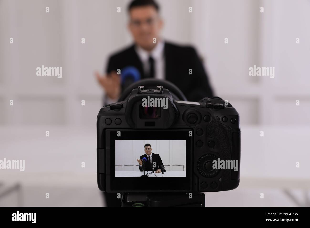 Business man giving interview at official event, focus on video camera ...