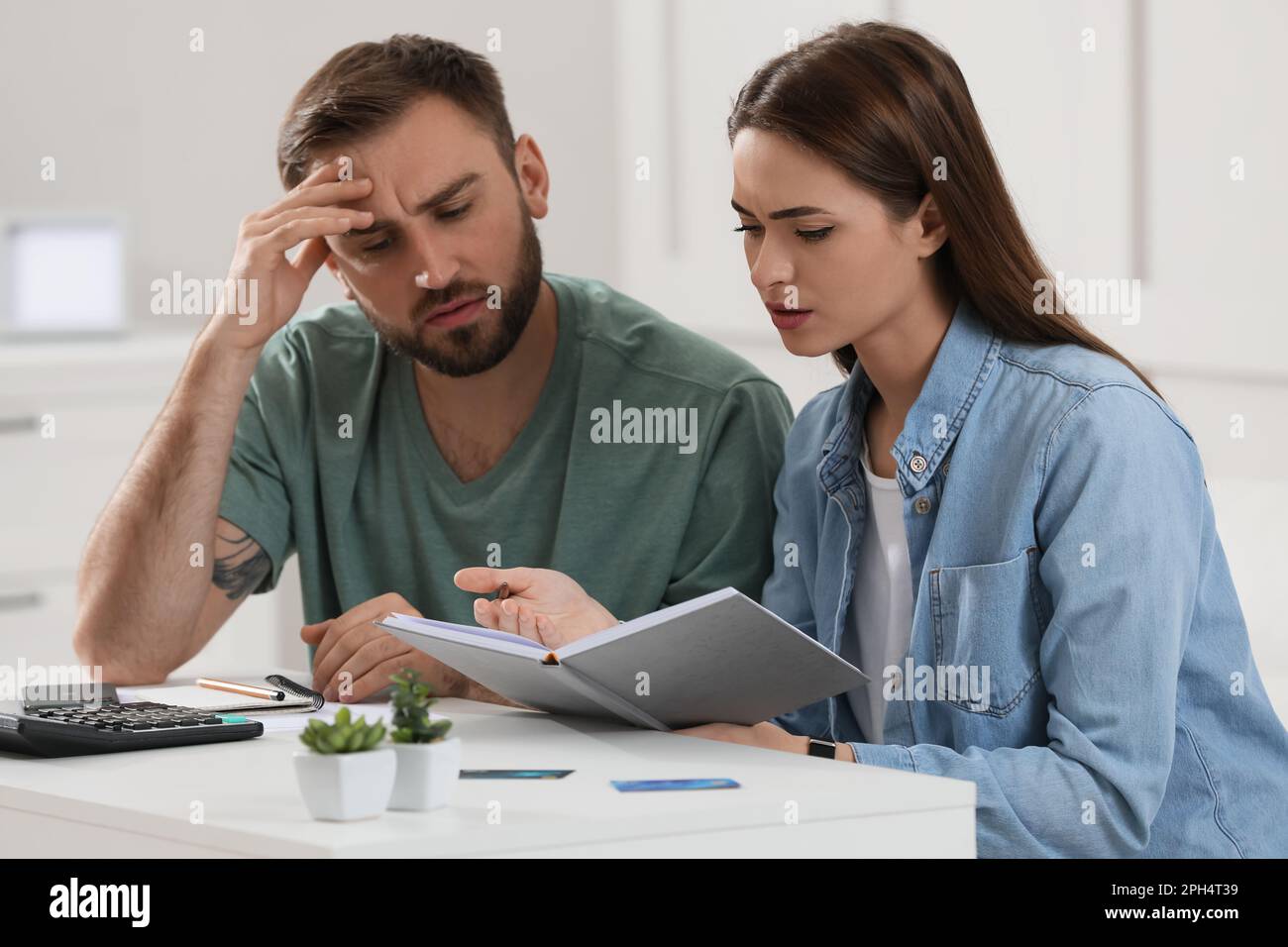 Young couple discussing family budget at home Stock Photo - Alamy