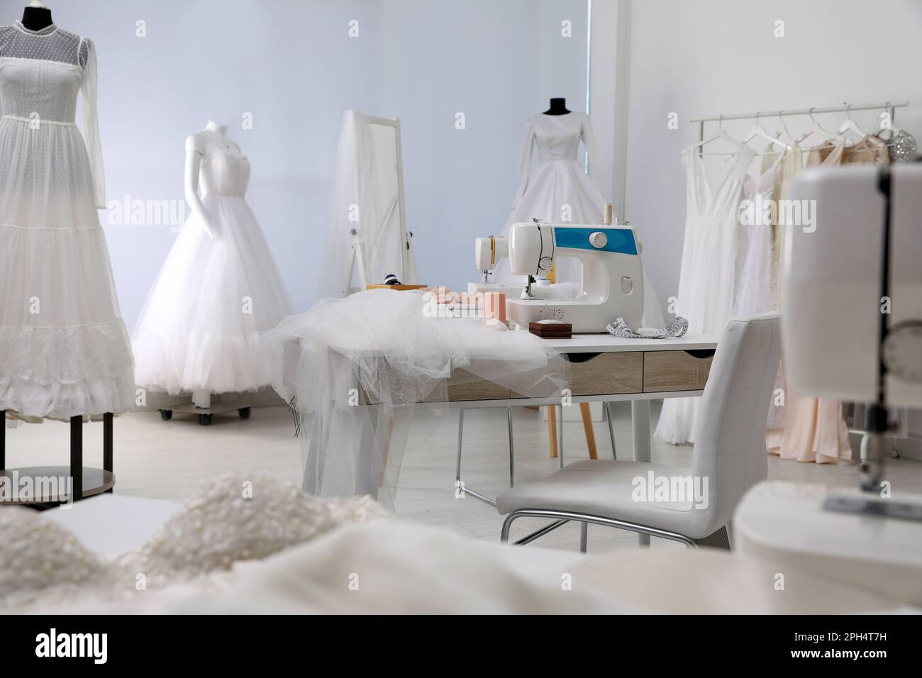 Dressmaking workshop interior with wedding dresses and equipment Stock ...