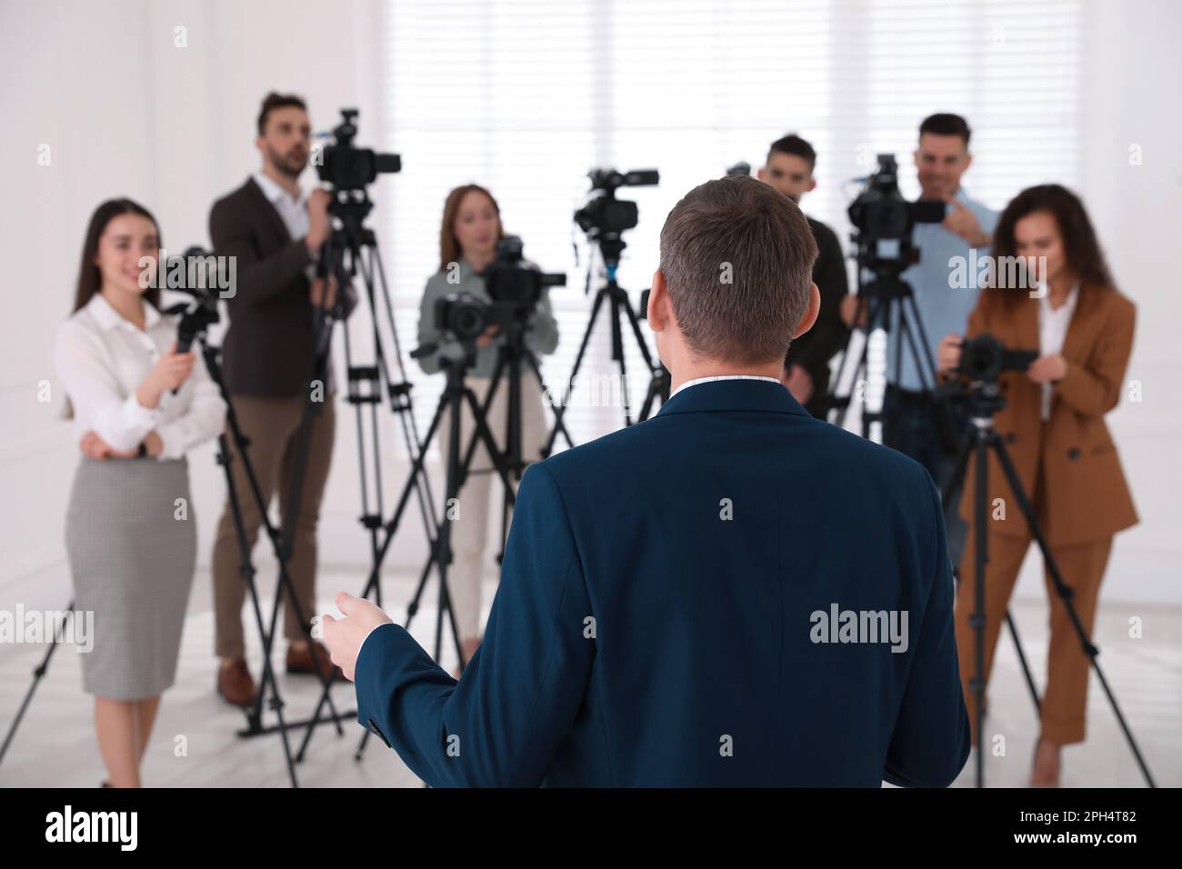 Business man talking to group of journalists indoors, back view Stock ...