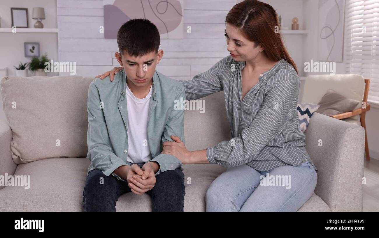 Mother consoling her depressed son at home. Teenager problems Stock ...