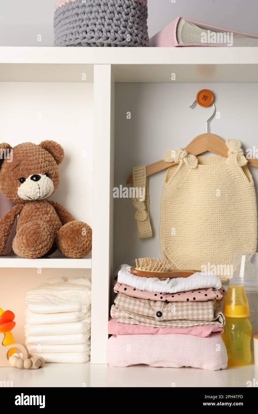 Baby clothes, toys and accessories on white rack Stock Photo - Alamy