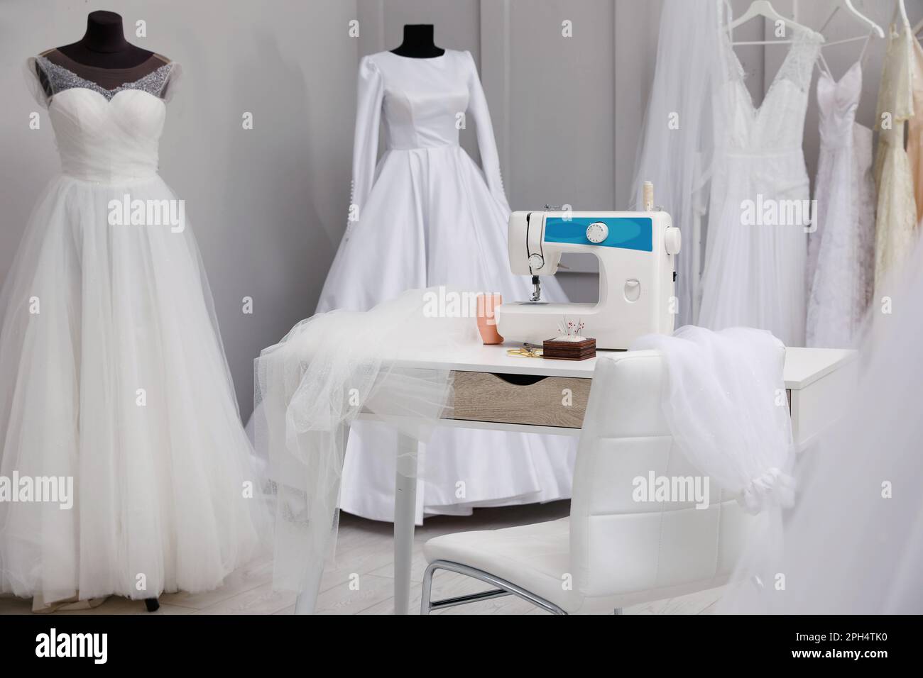Dressmaking workshop interior with wedding dresses and equipment Stock ...