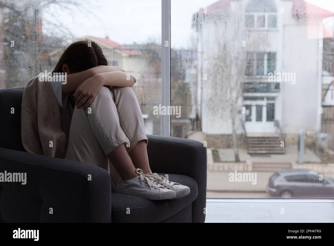 Sad young woman crying near window indoors, space for text. Loneliness ...