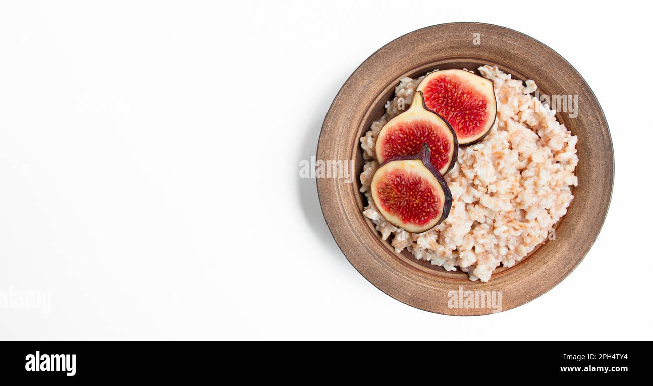 Oatmeal with fresh figs, almonds, cashews and fresh fruits on a white ...