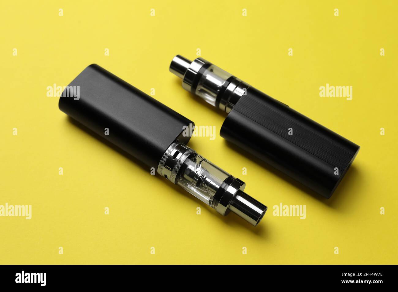 New reusable electronic cigarettes on yellow background Stock Photo - Alamy