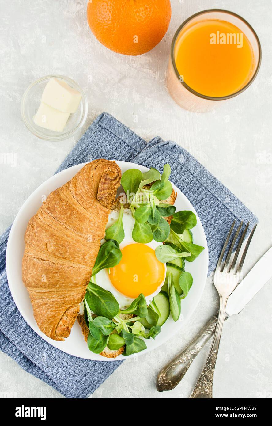 European breakfast with fresh croissants, scrambled eggs, herbs and ...