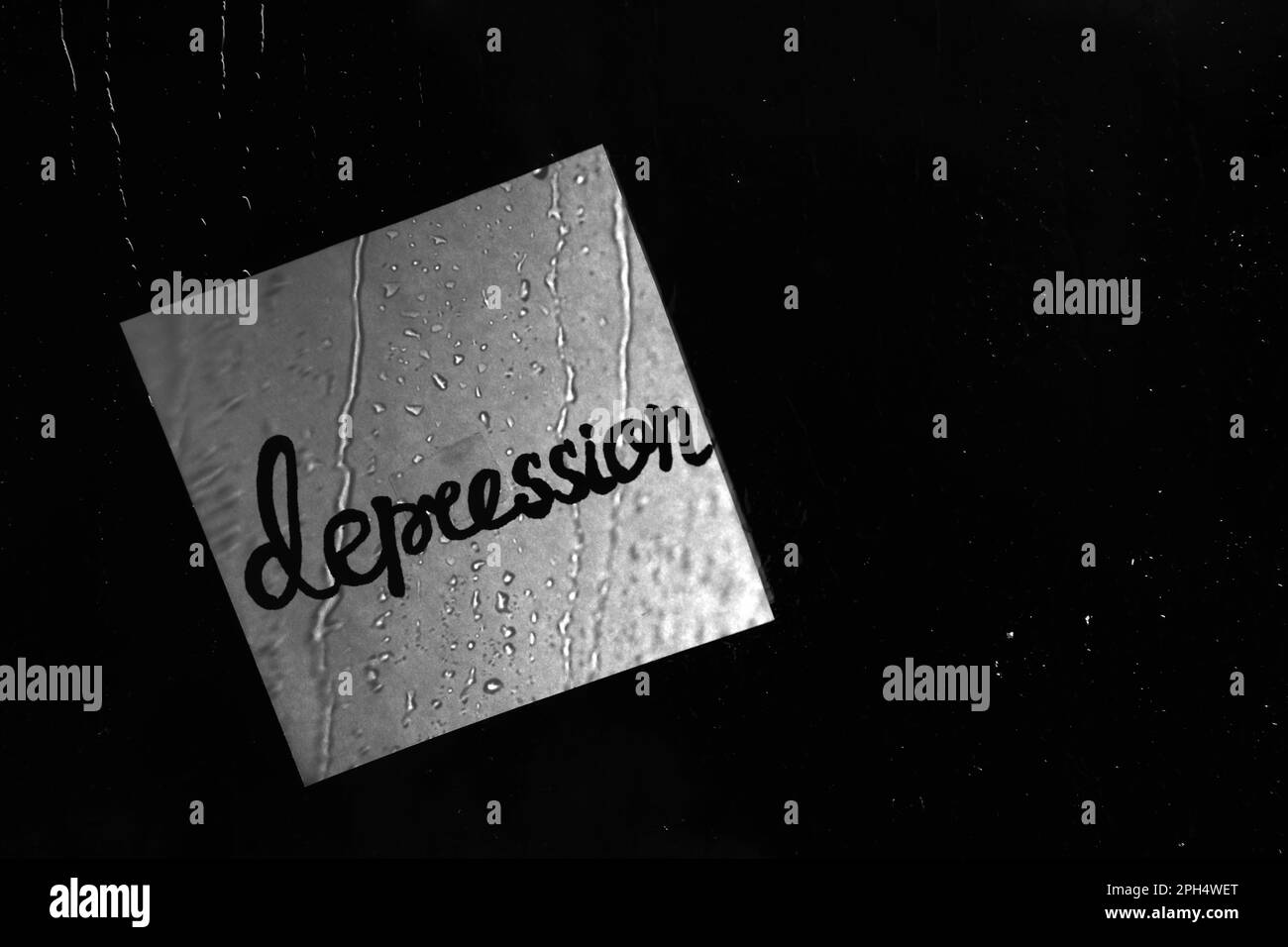 Paper sheet with word Depression on wet glass against dark background ...