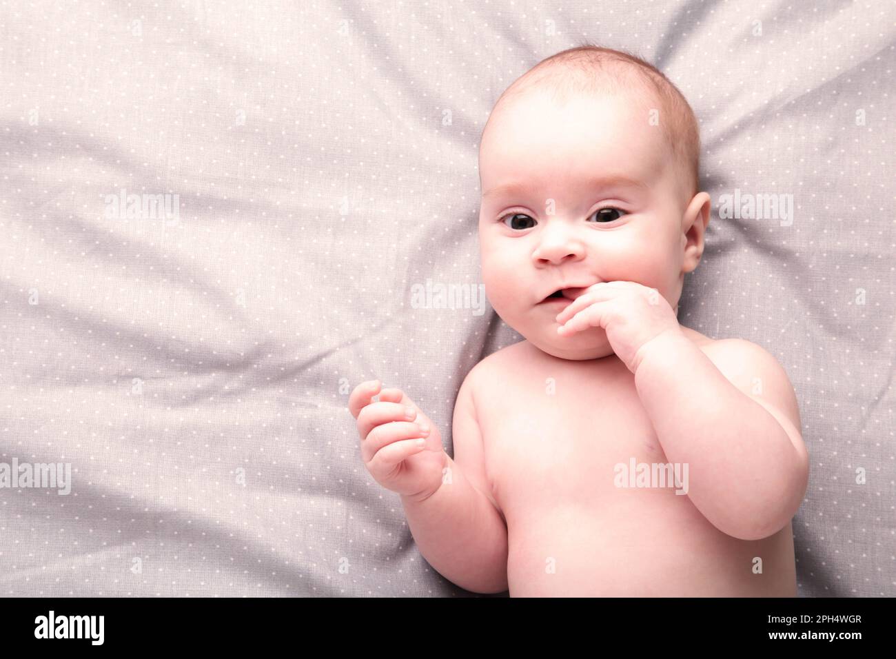 Cute baby in diaper lying with her fingers in mouth Stock Photo - Alamy
