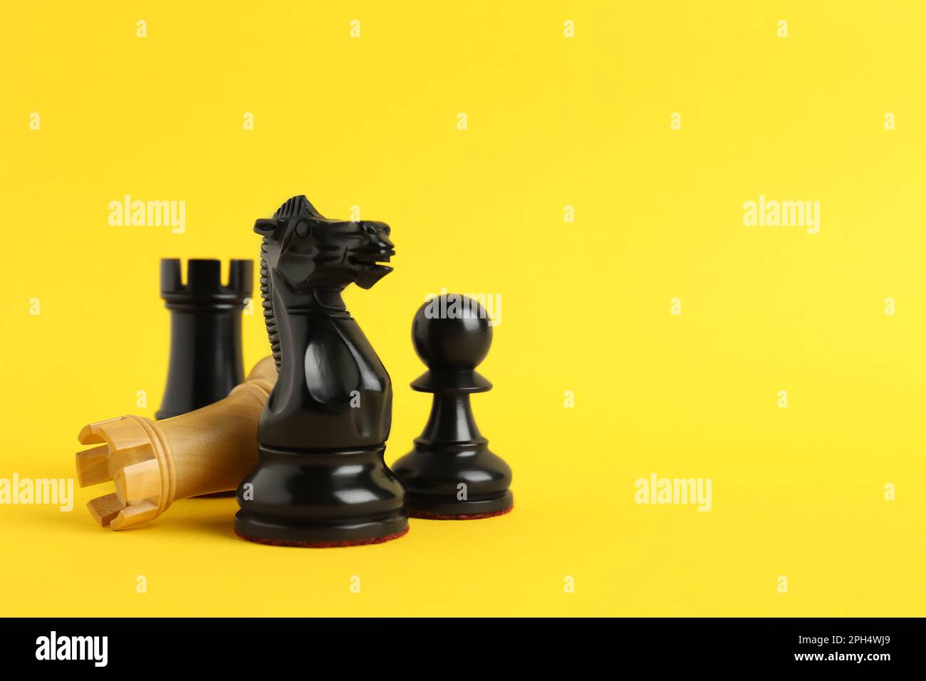 Different chess pieces on yellow background. Space for text Stock Photo ...