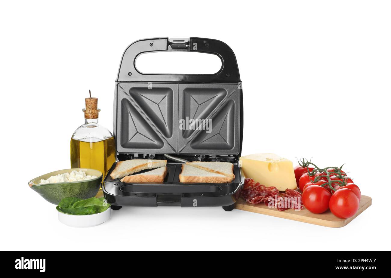 Modern sandwich maker with bread slices and different products on white ...