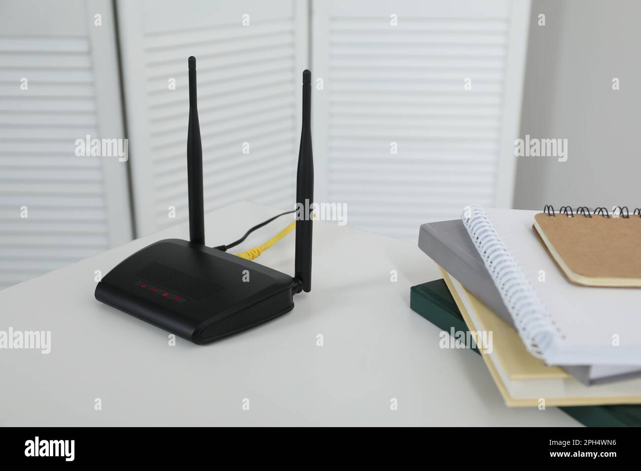 Modern Wi-Fi router on white table in room Stock Photo - Alamy