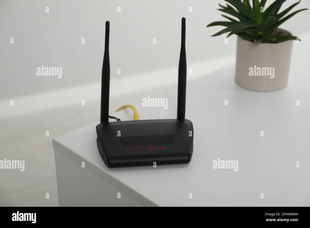 Modern Wi-Fi router on white table in room. Space for text Stock Photo ...