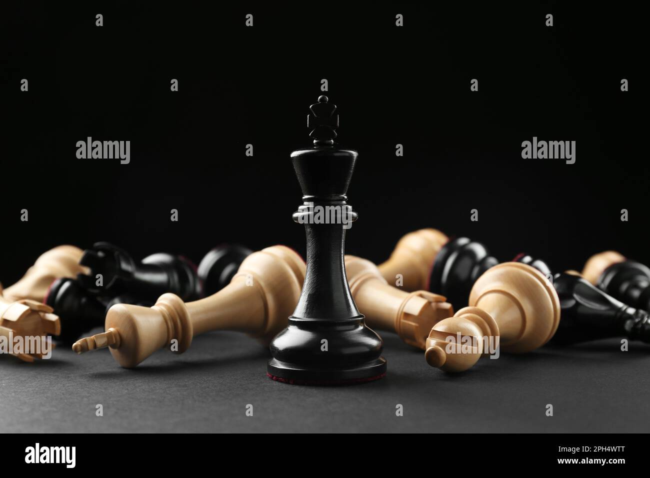 Black king among fallen chess pieces on dark background Stock Photo - Alamy