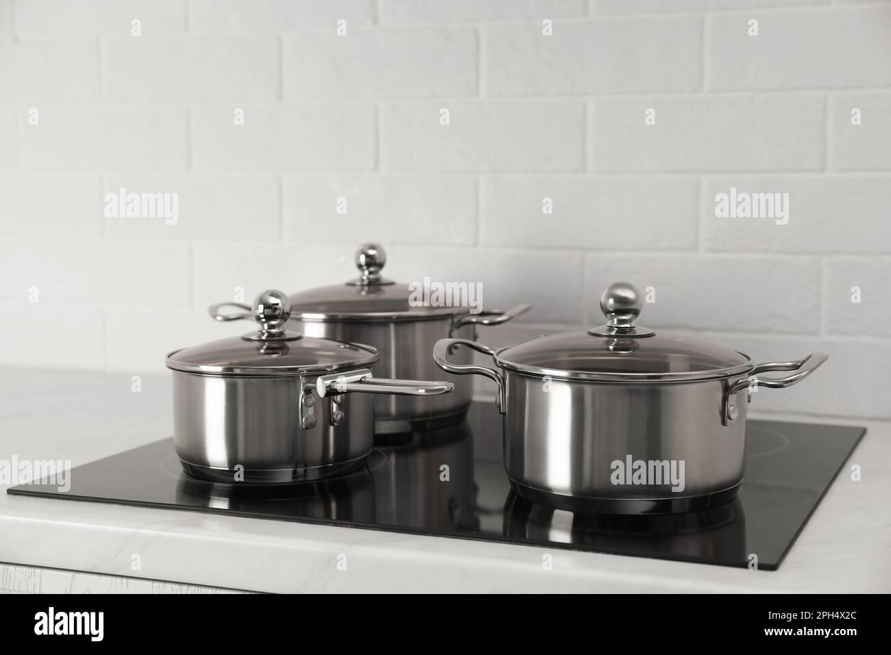 Set of new clean cookware on cooktop in kitchen Stock Photo - Alamy