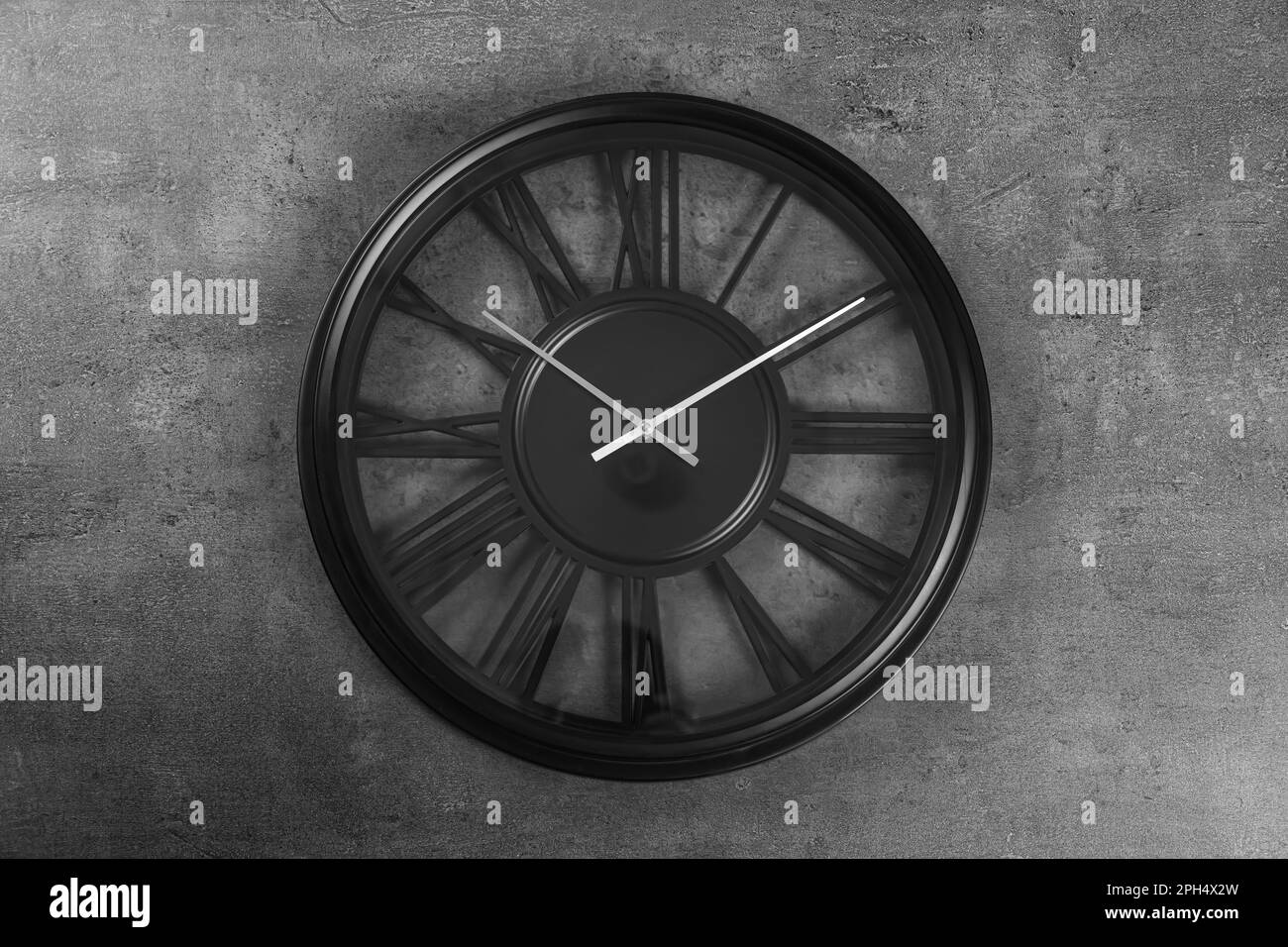 Stylish analog clock hanging on grey wall Stock Photo - Alamy