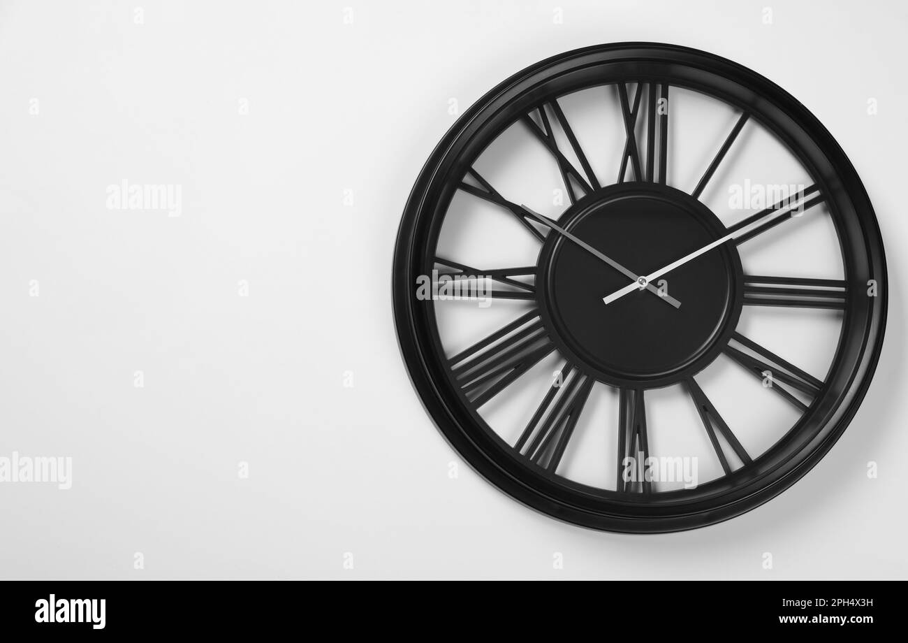 Stylish analog clock hanging on white wall, space for text Stock Photo ...