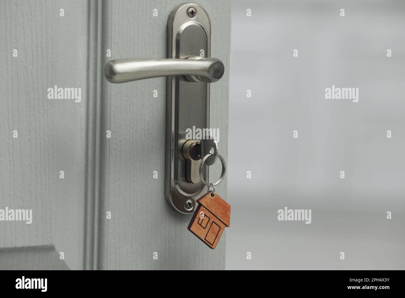 Key with house shaped fob in door lock, closeup. Space for text Stock ...