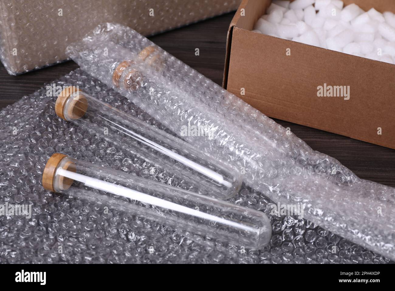 Test tubes with bubble wrap and cardboard box on table, closeup Stock ...