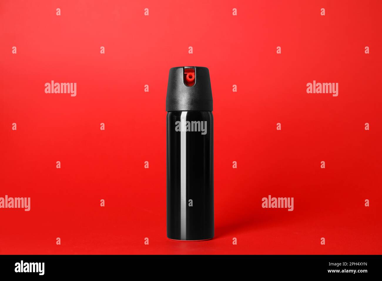 Bottle of gas pepper spray on red background Stock Photo - Alamy