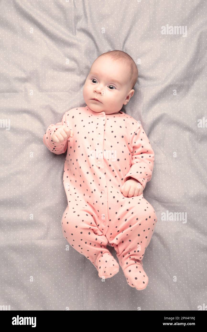 Cute baby on the grey bed, top view Stock Photo - Alamy