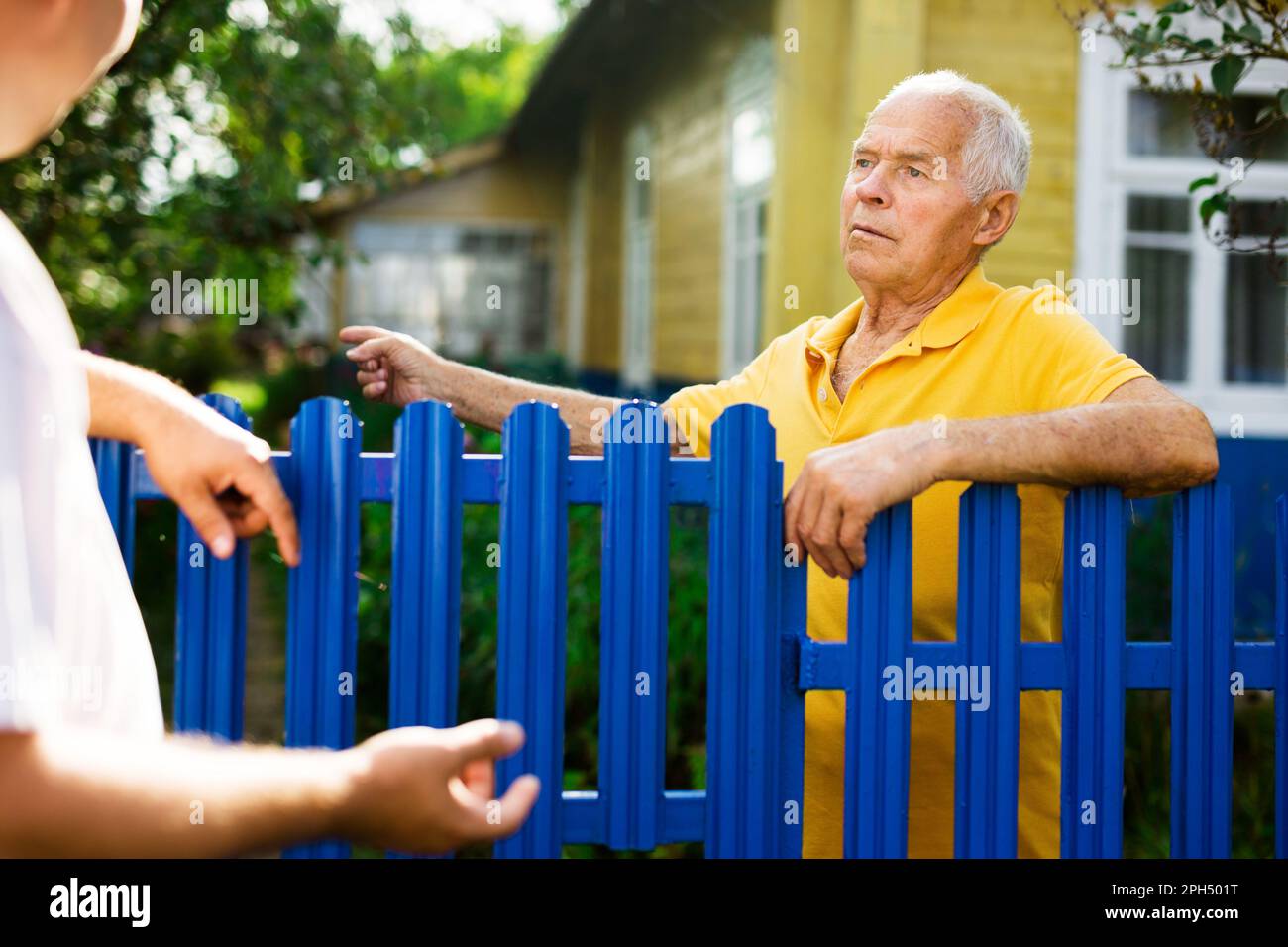 Senior man having conversation with his neighbour Stock Photo - Alamy