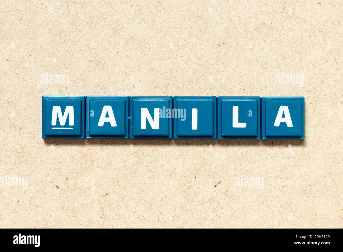 Tile alphabet letter in word manila on wood background Stock Photo - Alamy