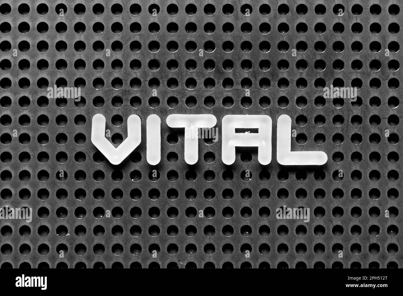White alphabet letter in word vital on black pegboard background Stock ...