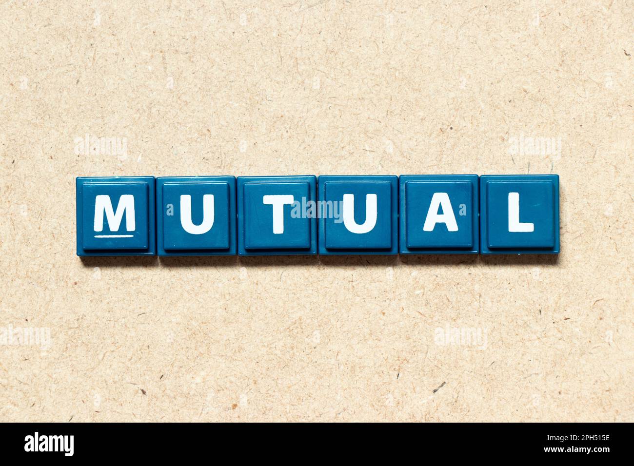 Tile alphabet letter in word mutual on wood background Stock Photo - Alamy