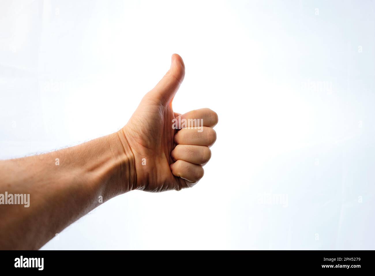 Man's hand with thumbs up, making the ok symbol, on a white background ...