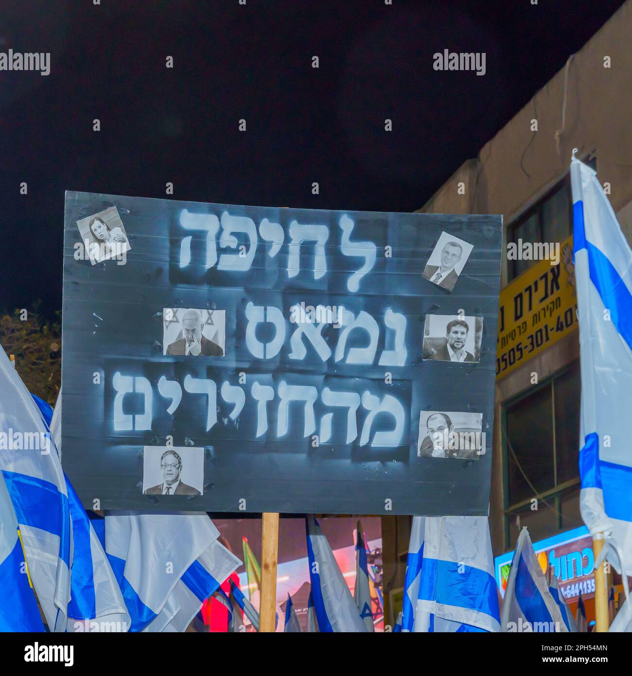 Haifa, Israel - March 25, 2023: Protesters with various signs and flags ...