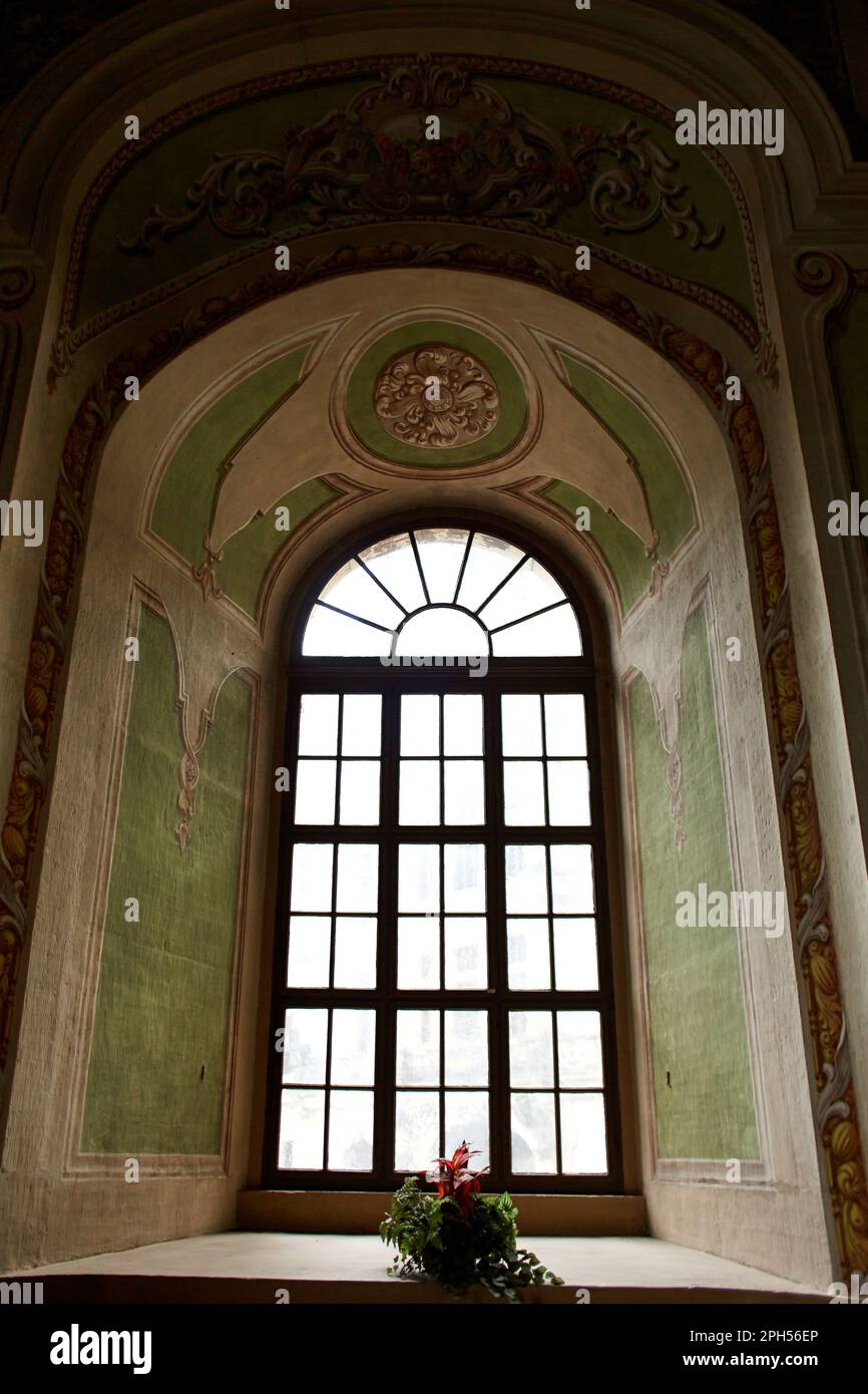 The interior is a vintage hall with a high ceiling and a huge window ...