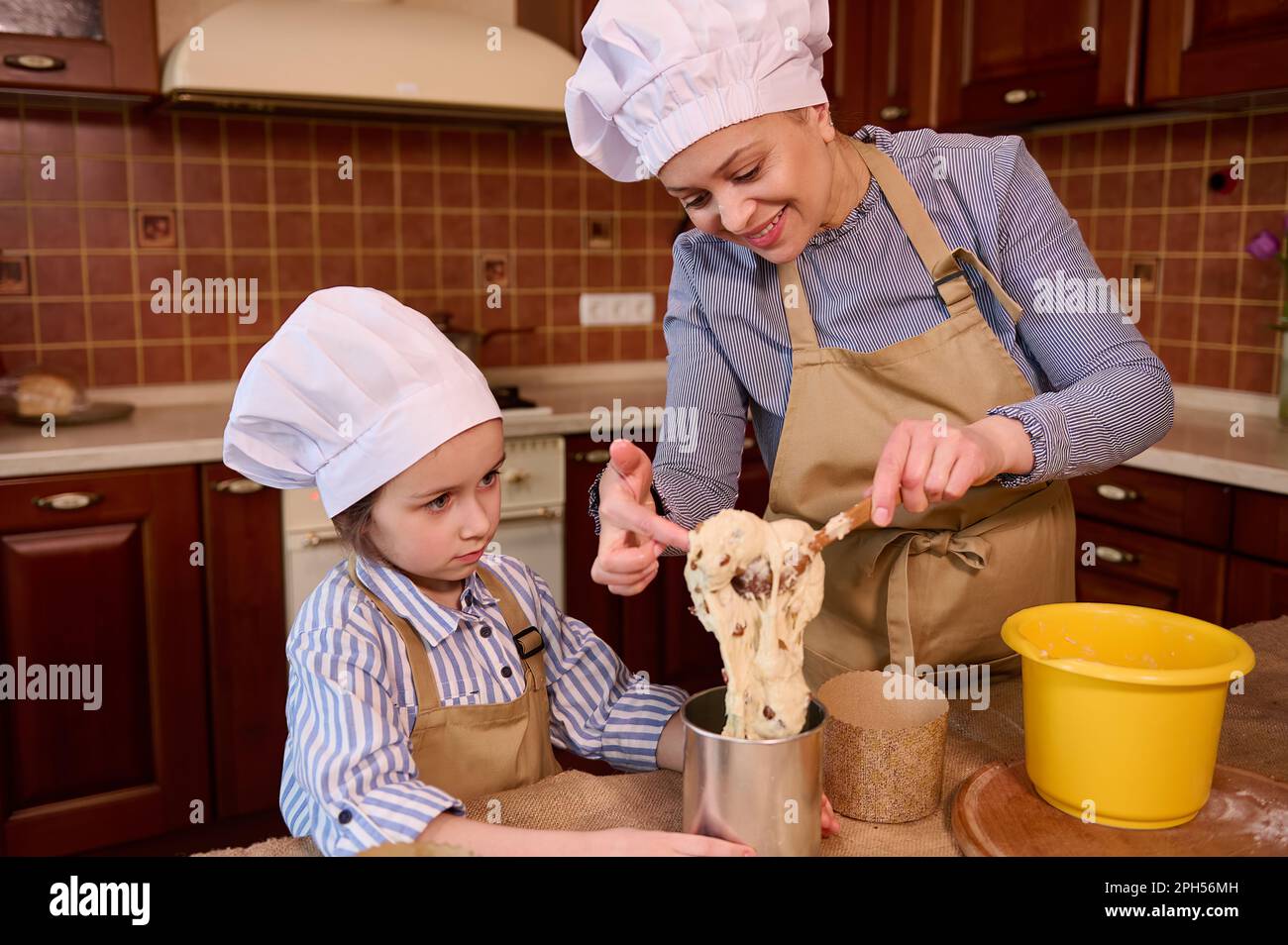 Loving cheerful mother and her adorable 5 years old daughter in chef's ...