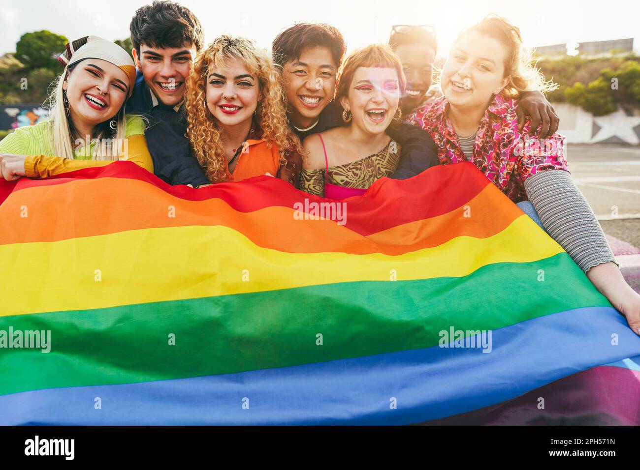 Young diverse people having fun holding LGBT rainbow flag outdoor ...
