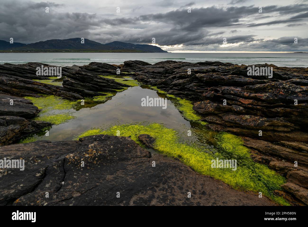 Rocks and tidal pool with green algae at Tramore beach, Kiltoorish ...