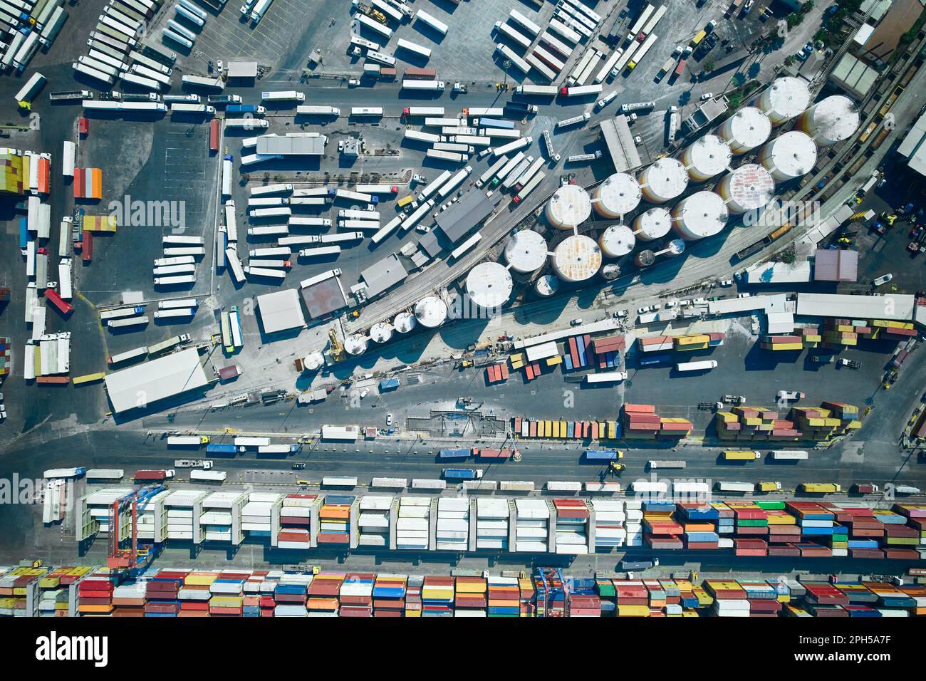 Stacked cargo containers and gas tanks top down aerial view. Containers at logistics terminal ...