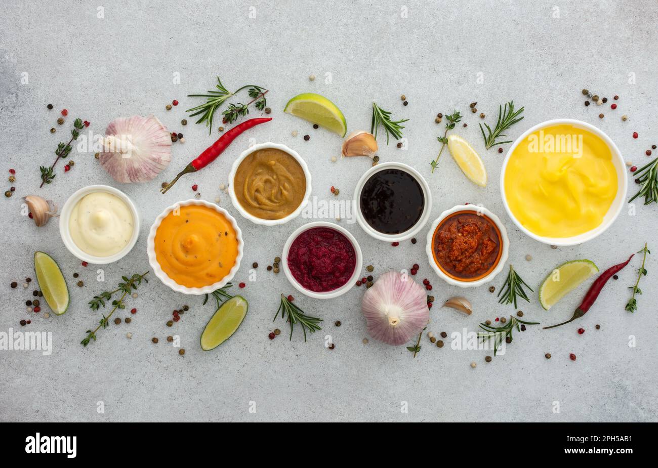 Different types of sauces in bowls with seasonings, rosemary and pepper ...