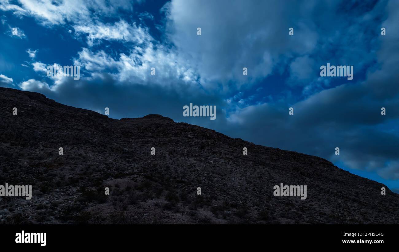 A beautiful landscape with low-hanging clouds in the sky over a dark ...