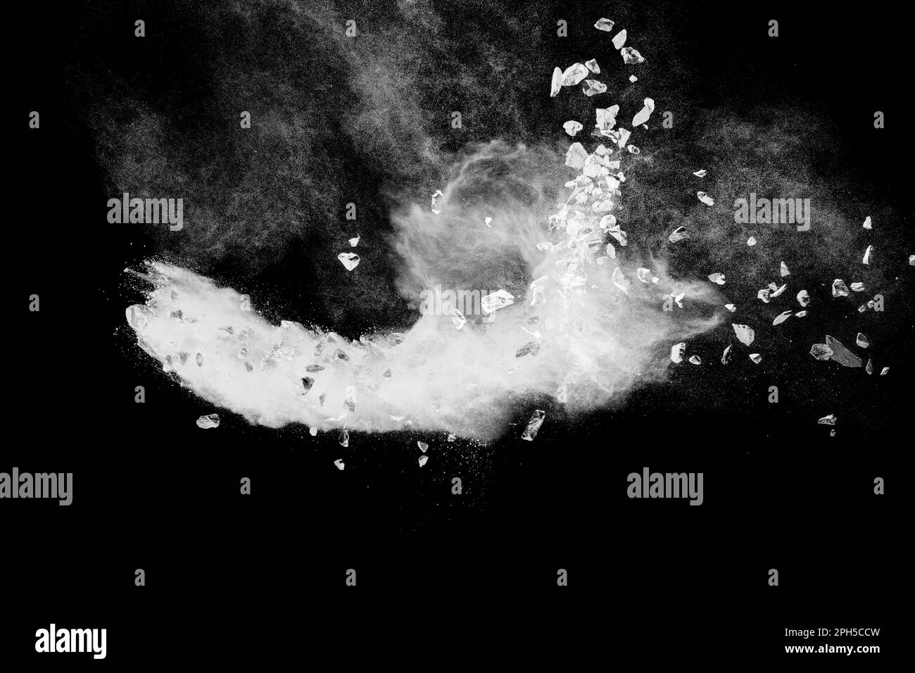 Split debris of stone exploding with white powder against black ...