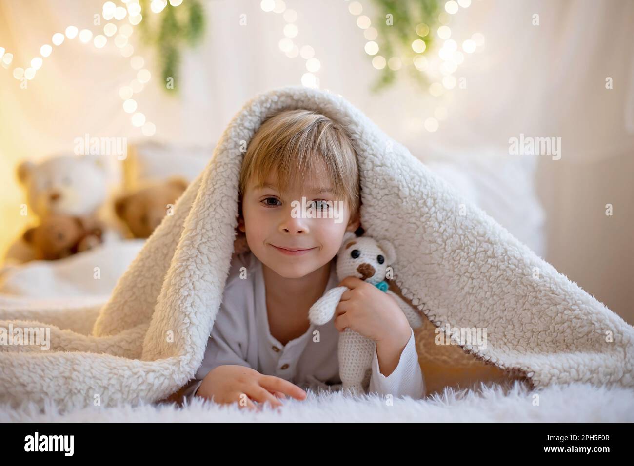 Little cute preschool boy, holding cute teddy bear, hiding under ...